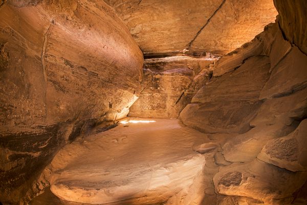A Desert Cave: A cave-like structure with a beam of light. The light ...